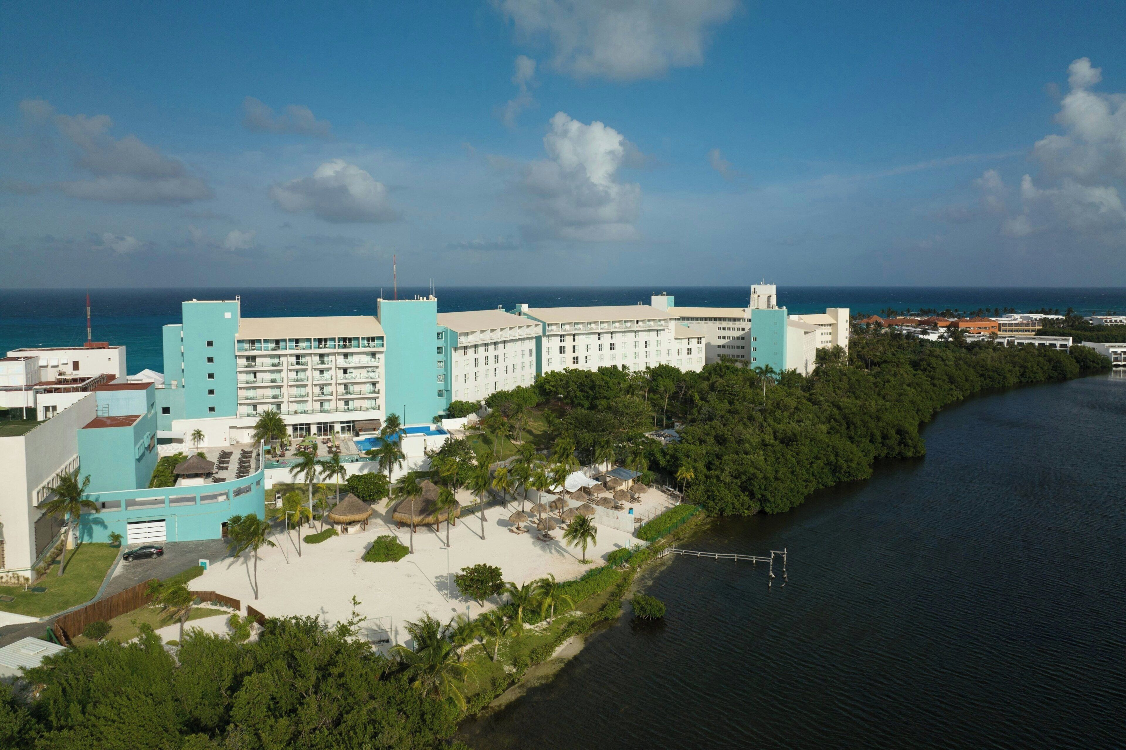 Um hotel à beira-mar com vários edifícios, praia e marina.