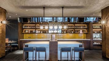 Área de bar moderna com ilha central e vários bancos.