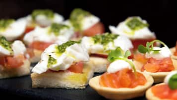 Diversos aperitivos apresentados em um prato de ardósia escura.