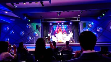 Espaço interior com palco, assentos e bolas de espelho.
