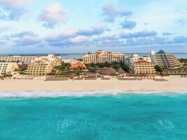Na praia, areia branca, espreguiçadeiras, guarda-sóis 