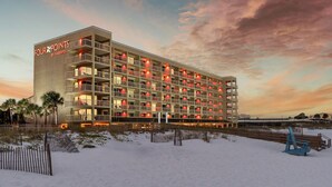 Um hotel de vários andares com design moderno, com varandas e uma sinalização chamativa.