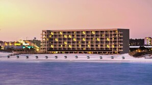 Um hotel com vários andares, design arquitetônico moderno, com varandas e vista para o rio.