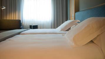 Quarto de hotel com uma cama bem arrumada, uma mesa de cabeceira e uma luminária.