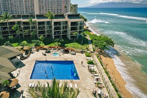 Um hotel com piscina, acesso à praia e vista para o oceano.
