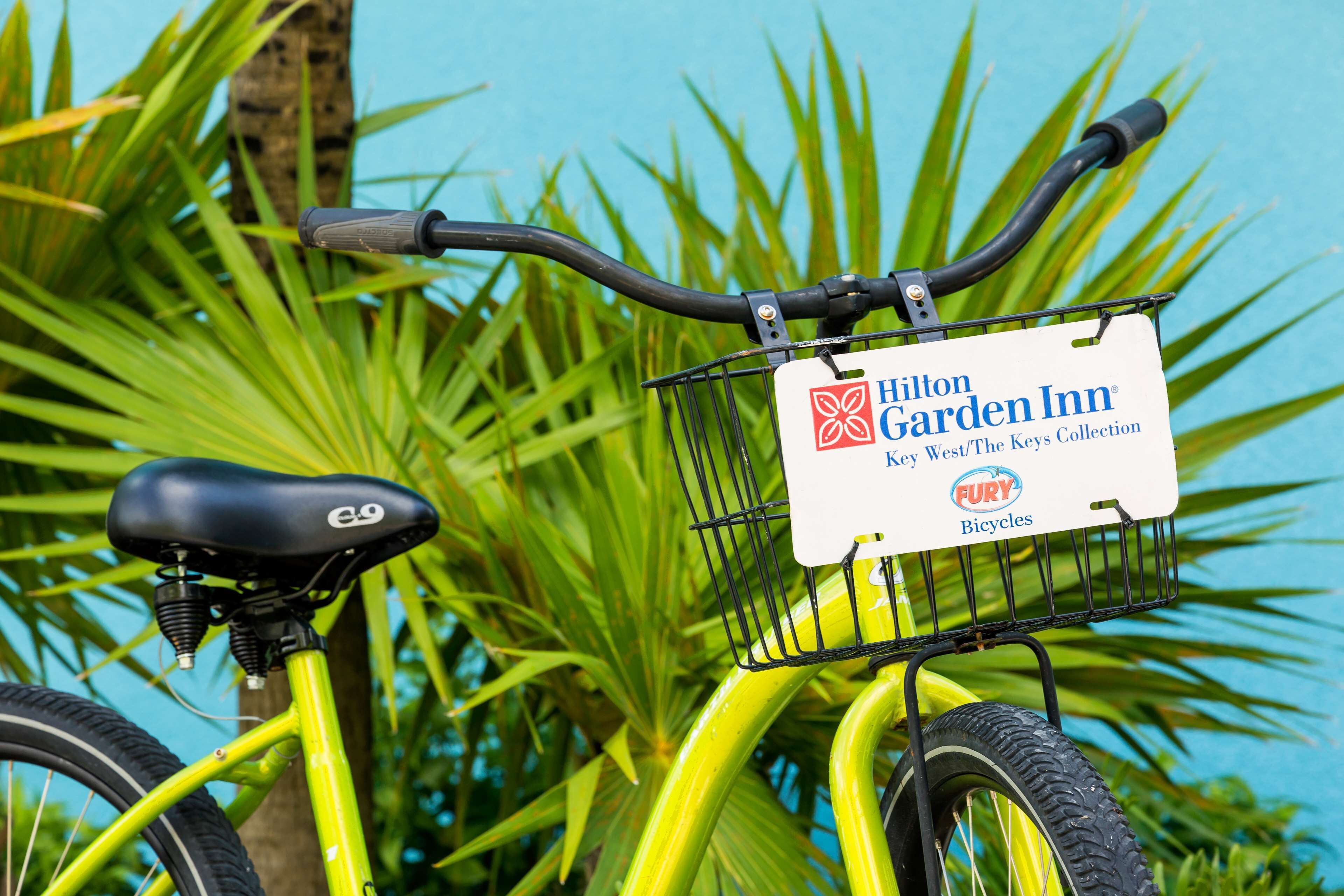 Uma bicicleta com cesto e placa indicando que faz parte da coleção Key West do Hilton Garden Inn.