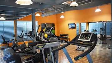 Uma academia com esteiras, elípticos e aparelhos de musculação.