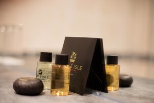 Um expositor preto com quatro frascos de perfume e uma caixa preta com a marca 'BLE ISLE'.