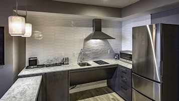 Um frigorífico, um micro-ondas, uma cafeteira/bule, uma cadeira de bebé