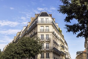 Um edifício com vários andares e estilo arquitetônico clássico, com varandas e janelas amplas.