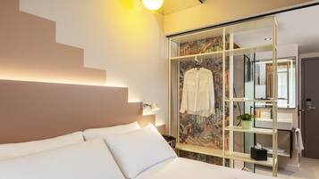 Quarto de hotel com cama, mesa de cabeceira, espelho e guarda-roupa com porta estampada.