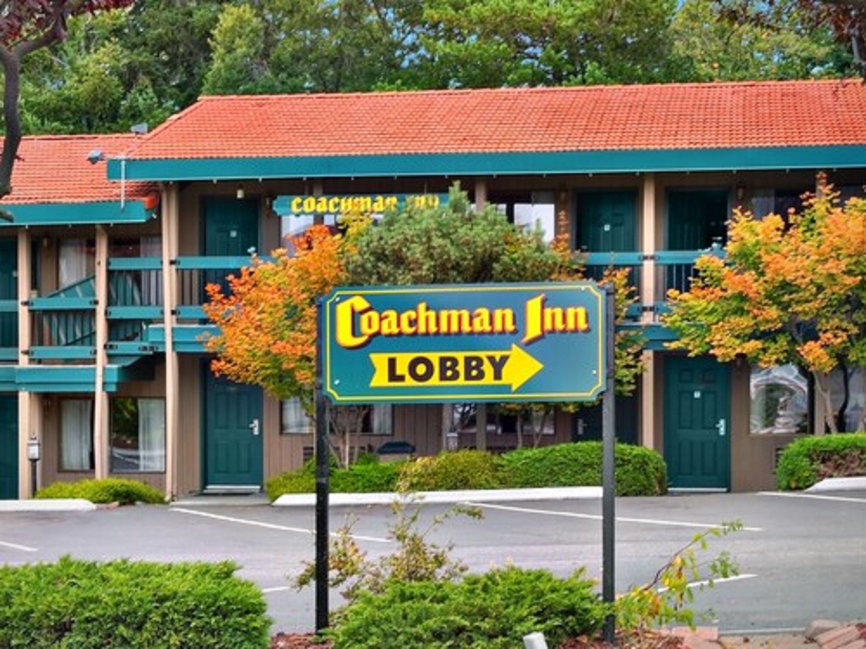 Uma hospedaria Coachman com telhado de telhas vermelhas e uma placa indicando a recepção.