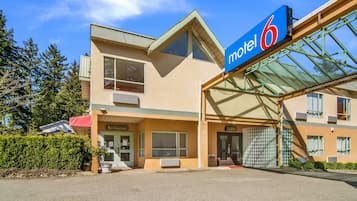 Um motel com um letreiro chamativo 'Motel 6', um restaurante e uma área de recepção.