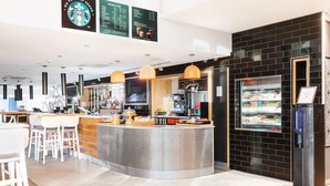 Um Starbucks moderno com balcão, área de estar e vitrines.