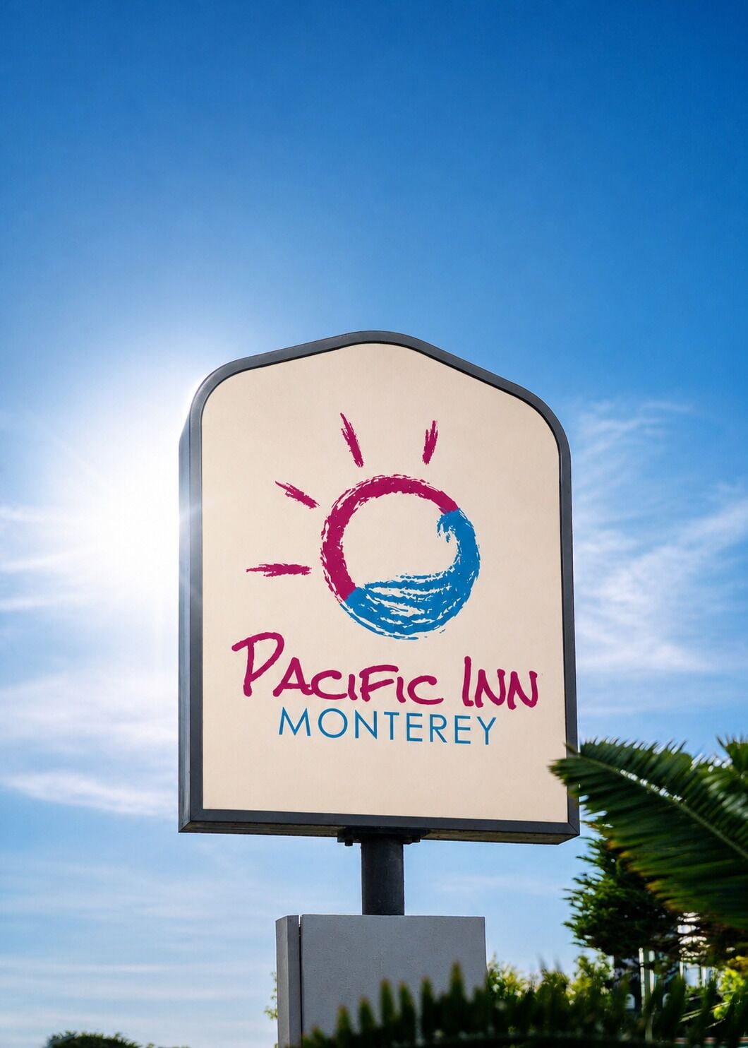 Placa do Pacific Inn Monterey com um logotipo estilizado do sol.