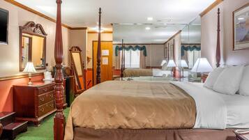 Quarto de hotel com cama de dossel, cômoda, espelho e janela com cortinas.