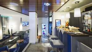 Um hall de hotel moderno com área de estar, balcão de recepção e bar.