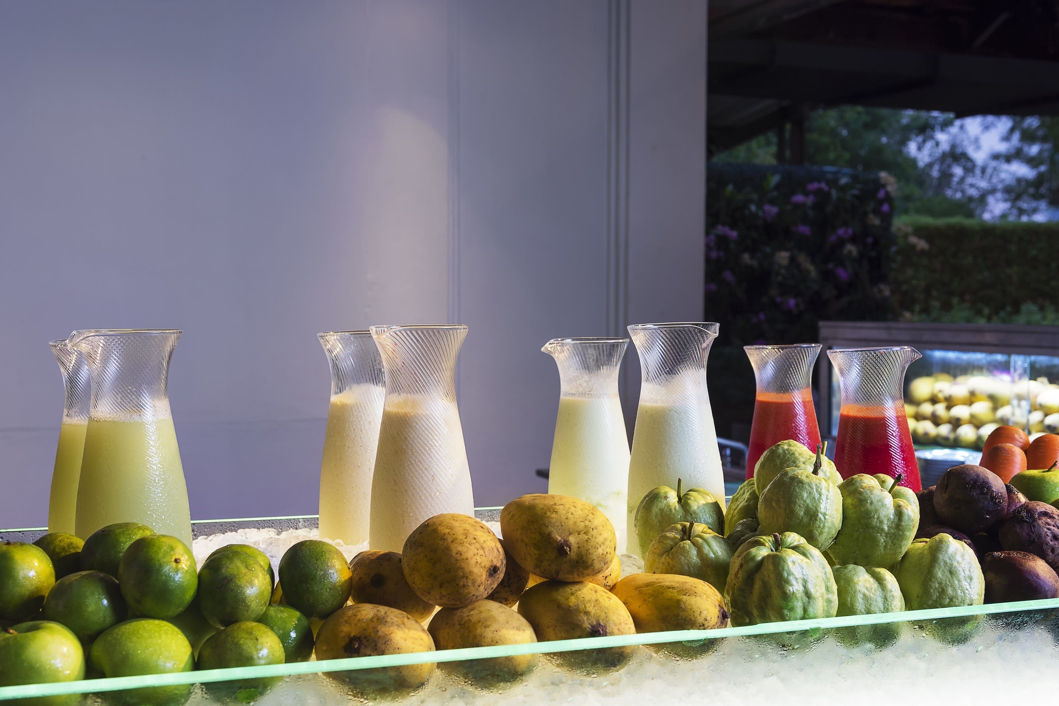 Um quiosque de bebidas com diversas opções de bebidas e frutas.