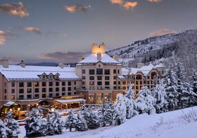 Um hotel grande com vários edifícios, uma área externa coberta e paisagem coberta de neve.