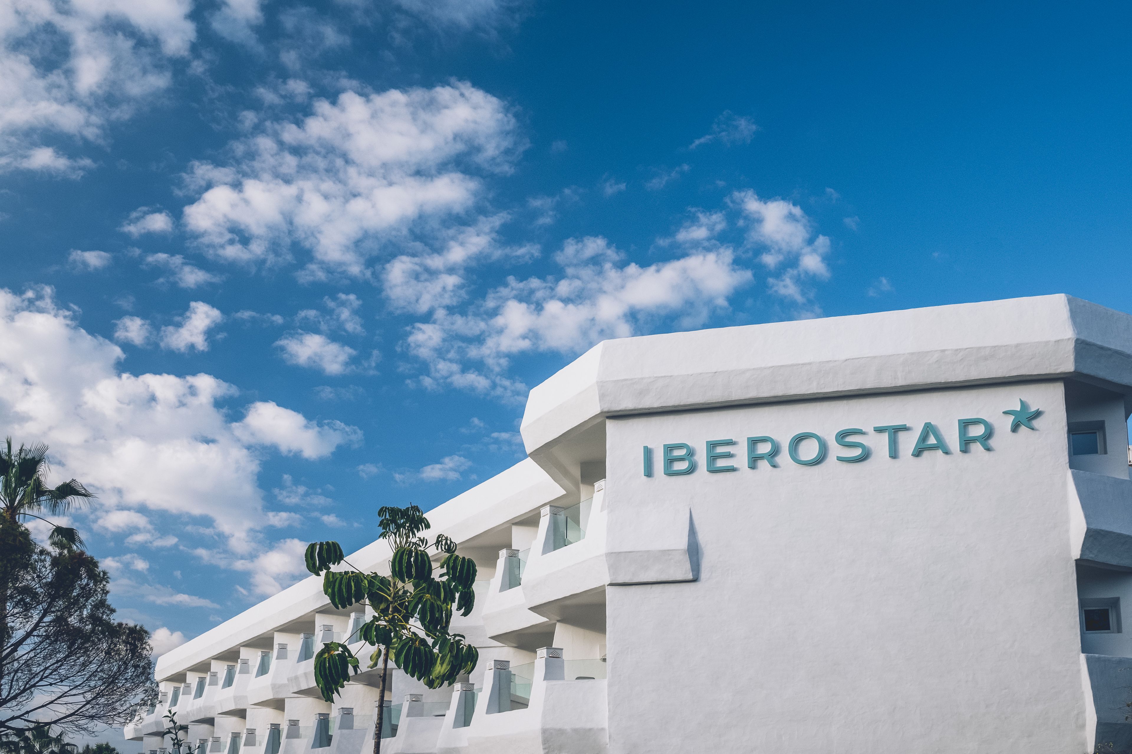 Um hotel moderno com fachada branca e o nome "IBEROSTAR" em destaque.