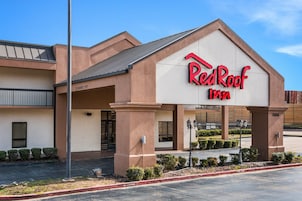 Edifício Red Roof Inn com placa visível, faixa de incêndio e estacionamento.