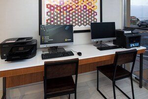 Uma área de trabalho com dois monitores, uma impressora e um teclado.