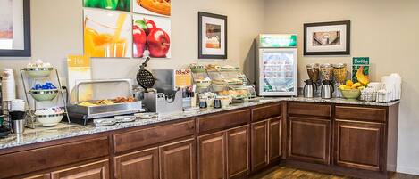 Buffet de café da manhã com diversas opções de alimentos e um espaço para café.