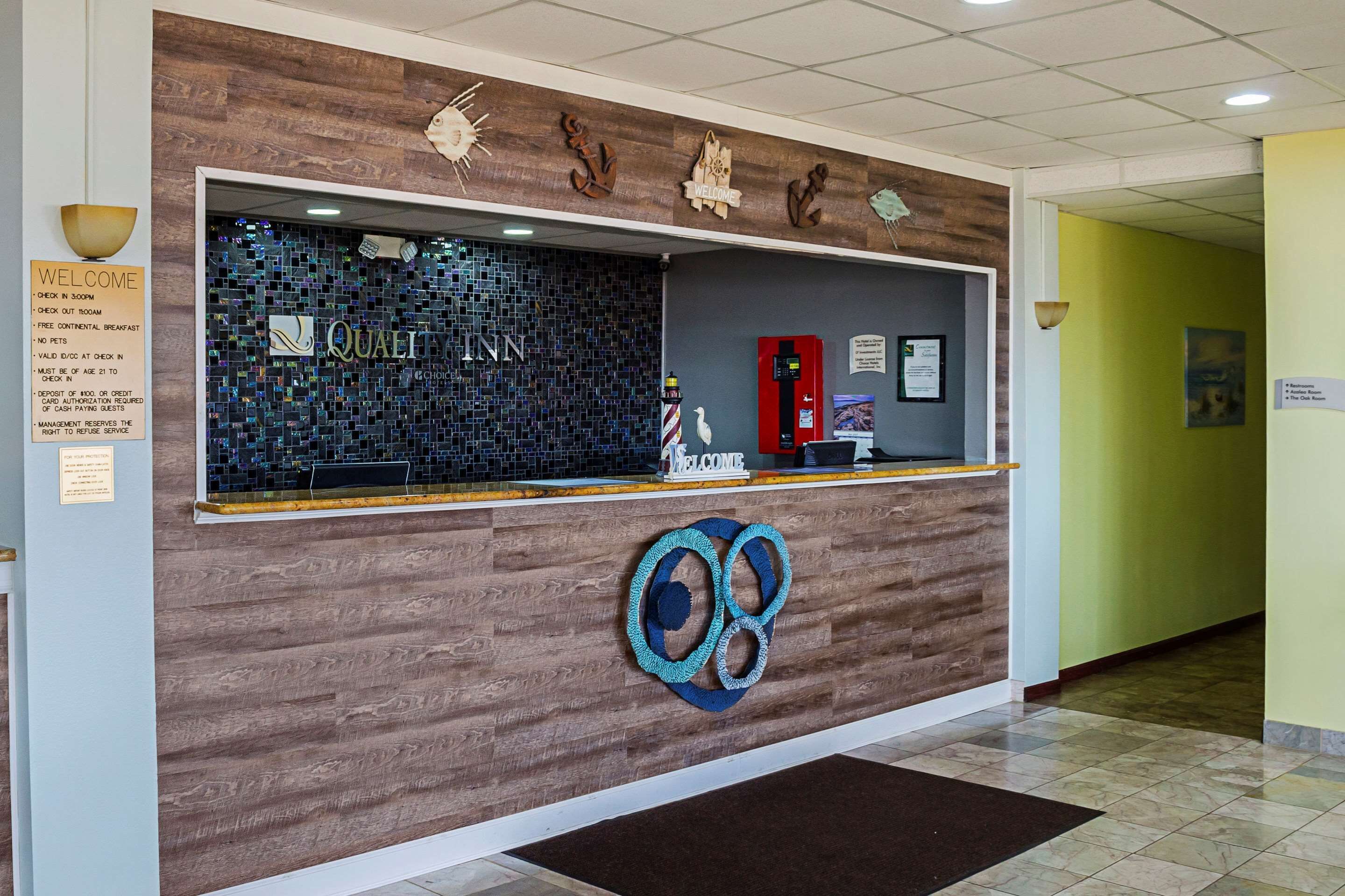 Uma receção com um painel de mosaicos, um aviso de 'Welcome' e o logotipo 'Qualinn'.