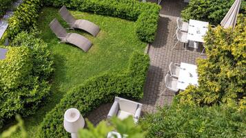 Um jardim no terraço com áreas de estar, um recurso de água e vista para a cidade.