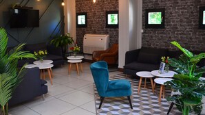 Uma área de estar moderna com sofás, mesas e plantas decorativas.