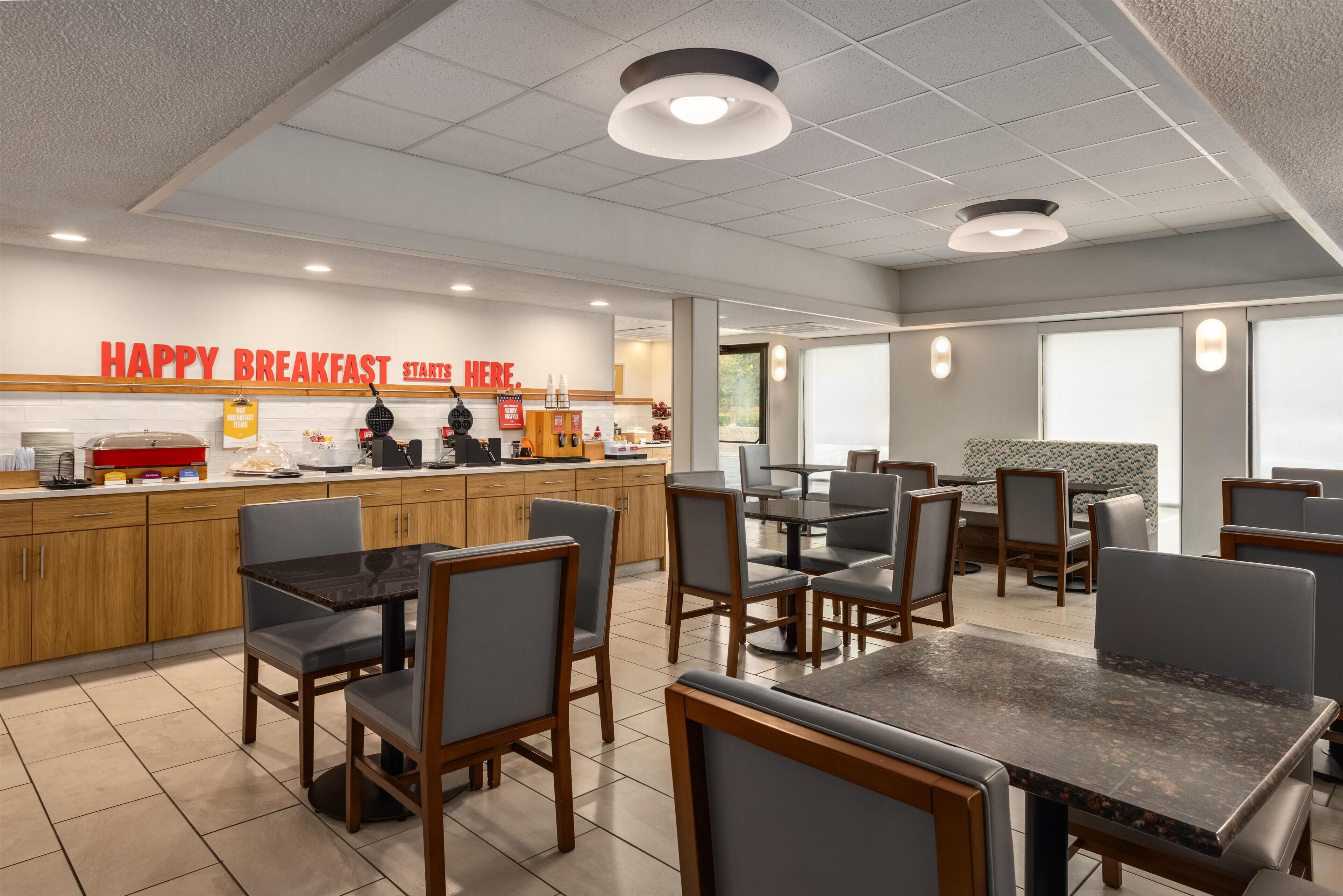 Espaço de café da manhã com balcão, assentos e vista para o exterior.