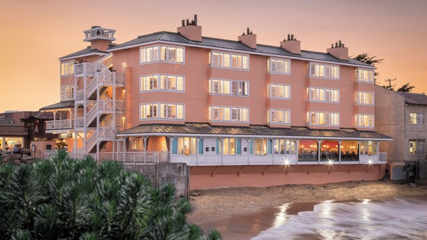 Um hotel com vários andares, varandas, localização à beira-mar e vista para o oceano.