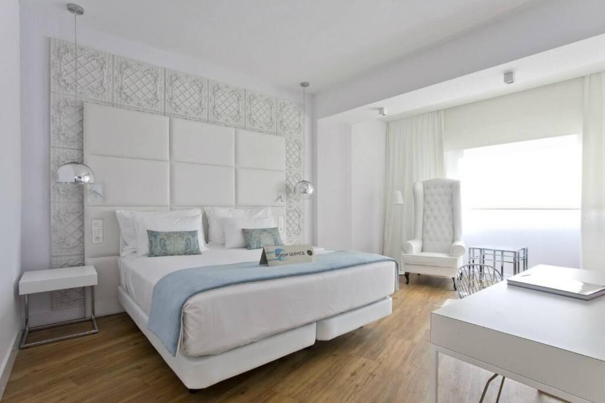 Um quarto moderno com uma cama, mesas de cabeceira, uma escrivaninha e uma cadeira.