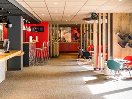 Um interior moderno com balcão de recepção, bar e área de estar.