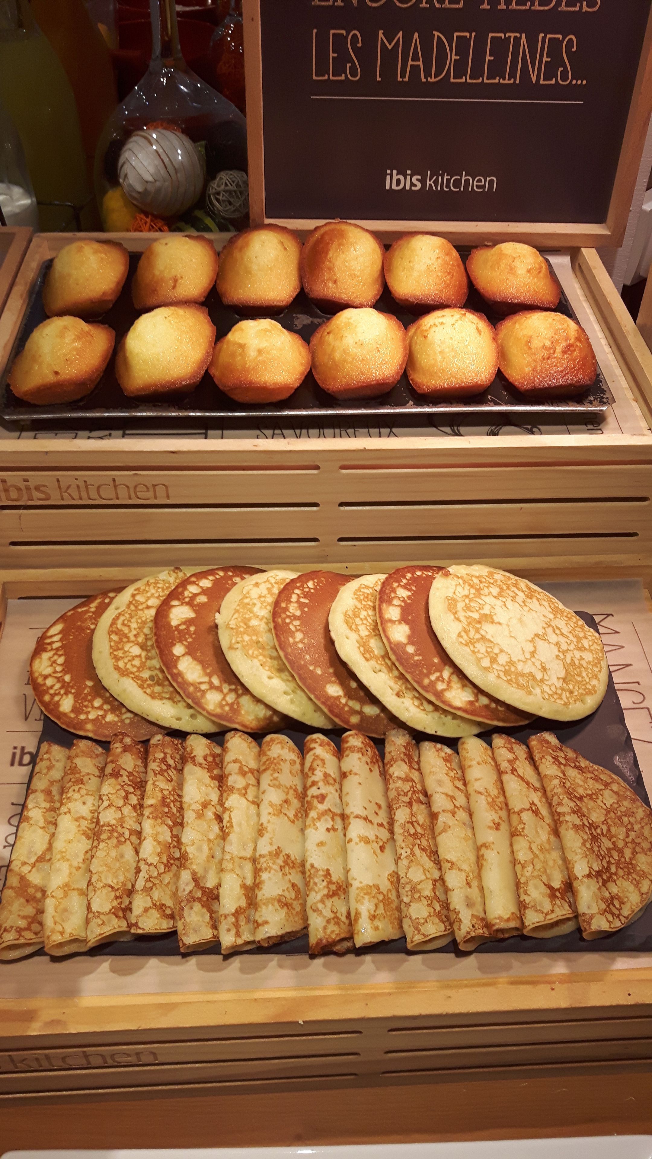Uma variedade de produtos de panificação, incluindo pastéis redondos e retangulares, em uma cozinha.