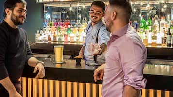 Uma área de bar com diversos frascos e copos nas prateleiras.