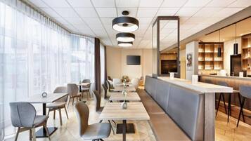 Um restaurante moderno com um balcão comprido, cabines e área de bar.