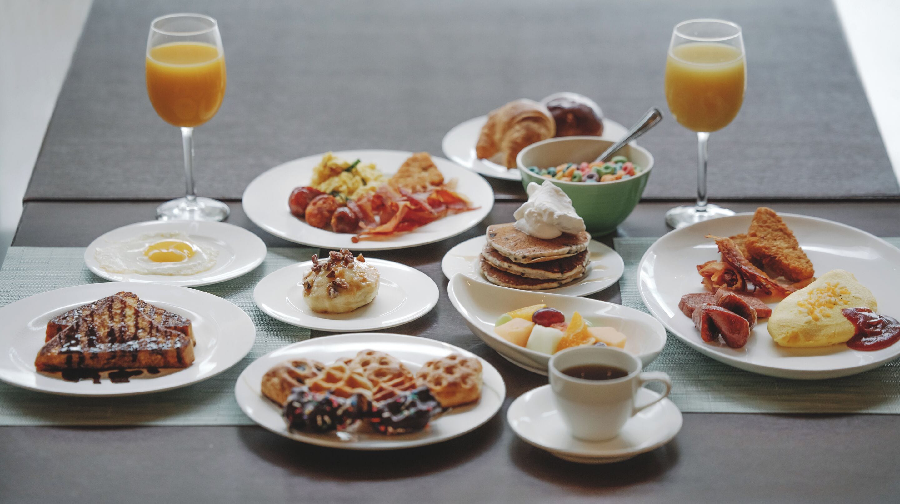Uma mesa posta com diversos pratos e bebidas para o café da manhã.