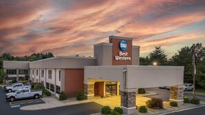 Um hotel Best Western com fachada moderna, estacionamento e céu claro.