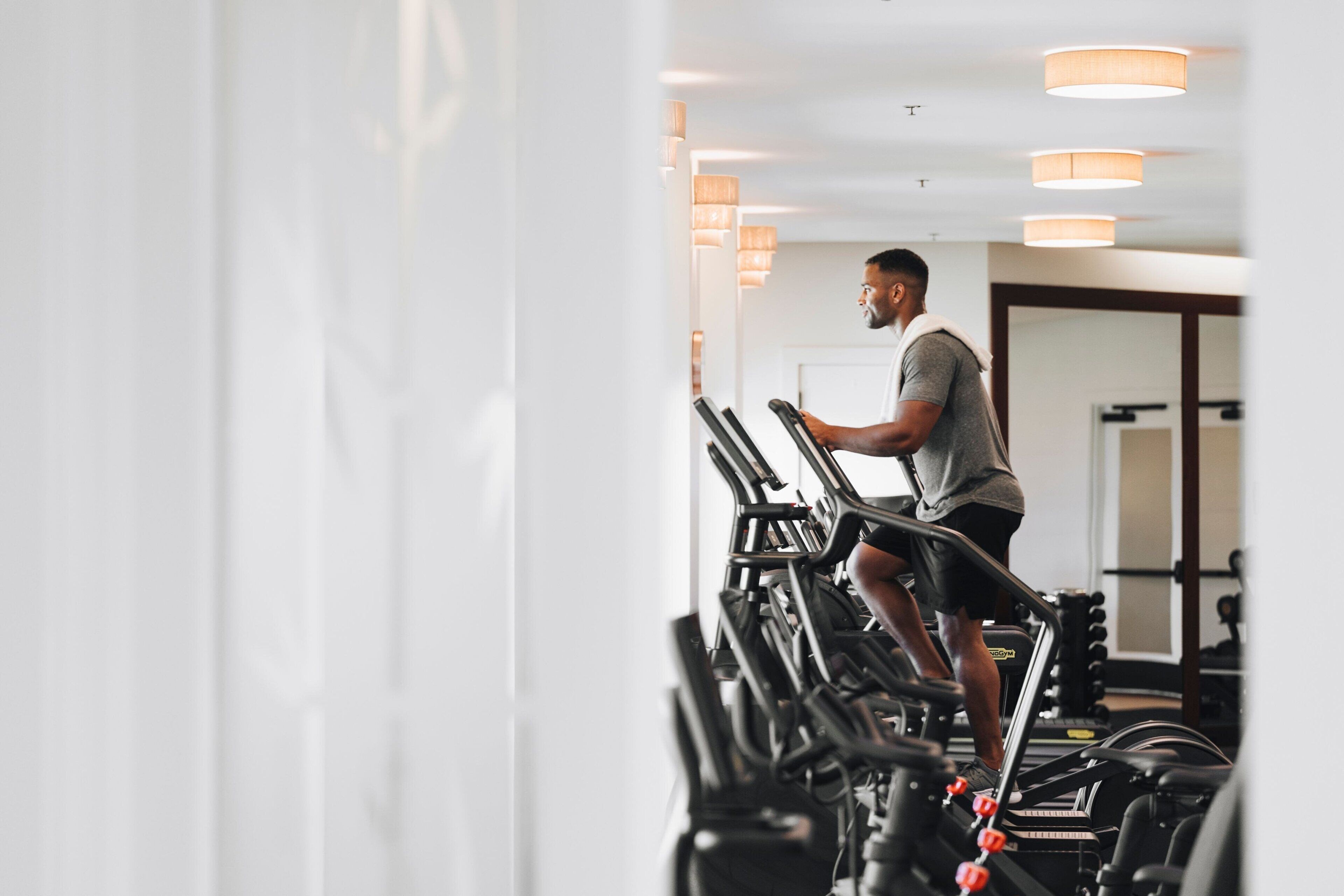 Uma academia com esteiras e máquinas de musculação.