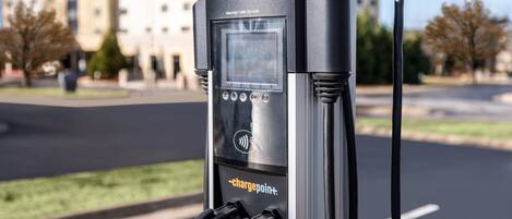 Uma estação de carregamento para veículos elétricos chargepoint+, com visor digital, cabos de carregamento e teclado.