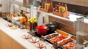 Buffet com diversos alimentos, acompanhamentos e utensílios.
