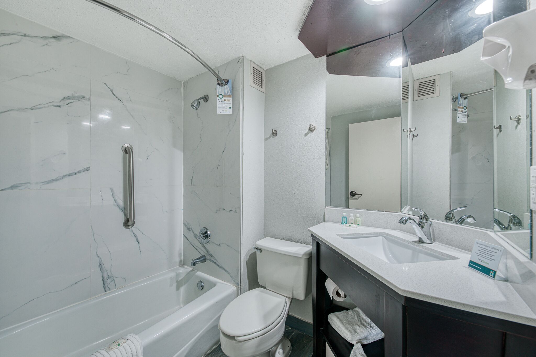 Uma casa de banho moderna com banheira, sanita e lavatório.