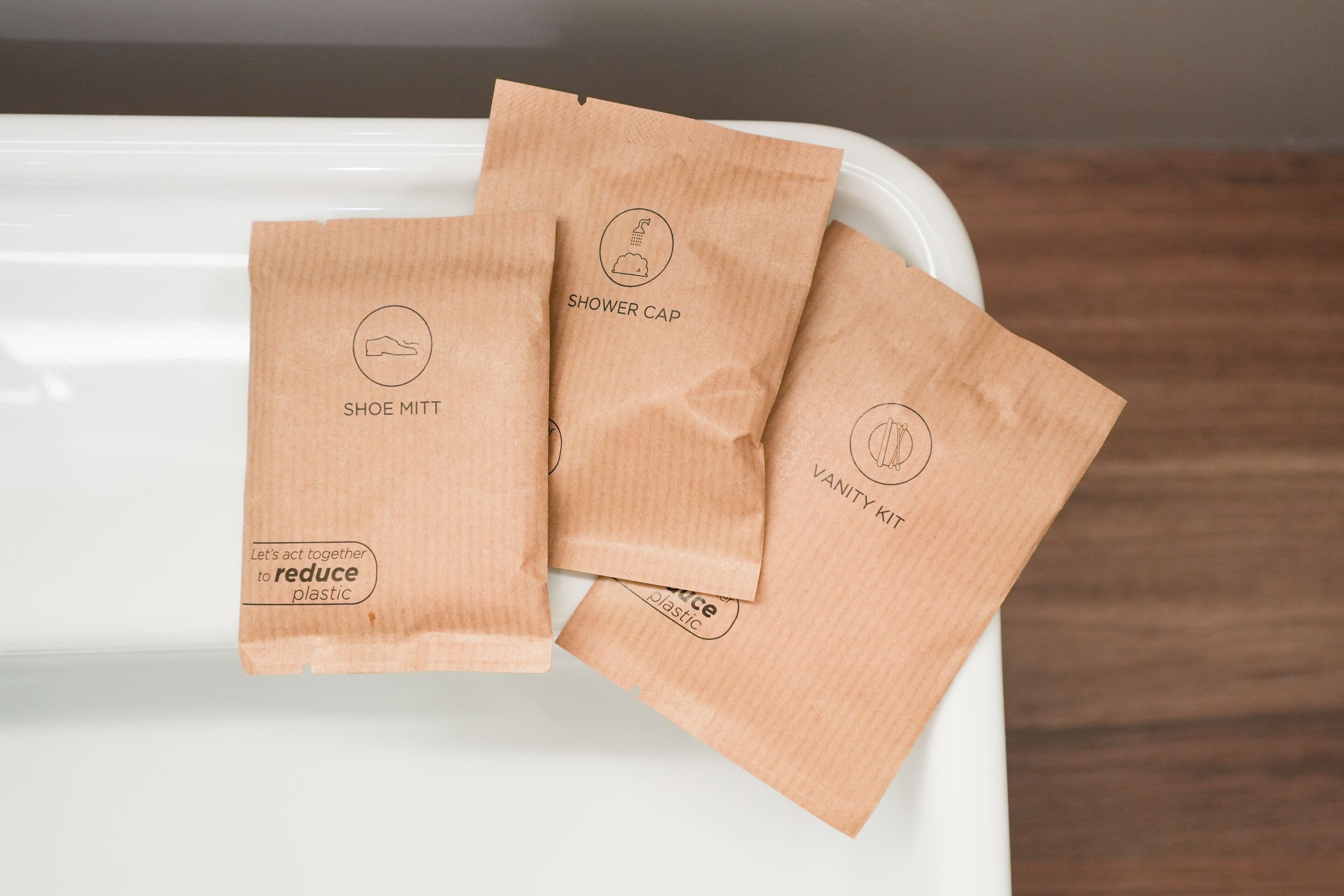 Três sacos de papel castanhos com logotipos e texto sobre uma superfície branca.