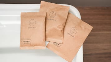 Três sacos de papel castanhos com logotipos e texto sobre uma superfície branca.