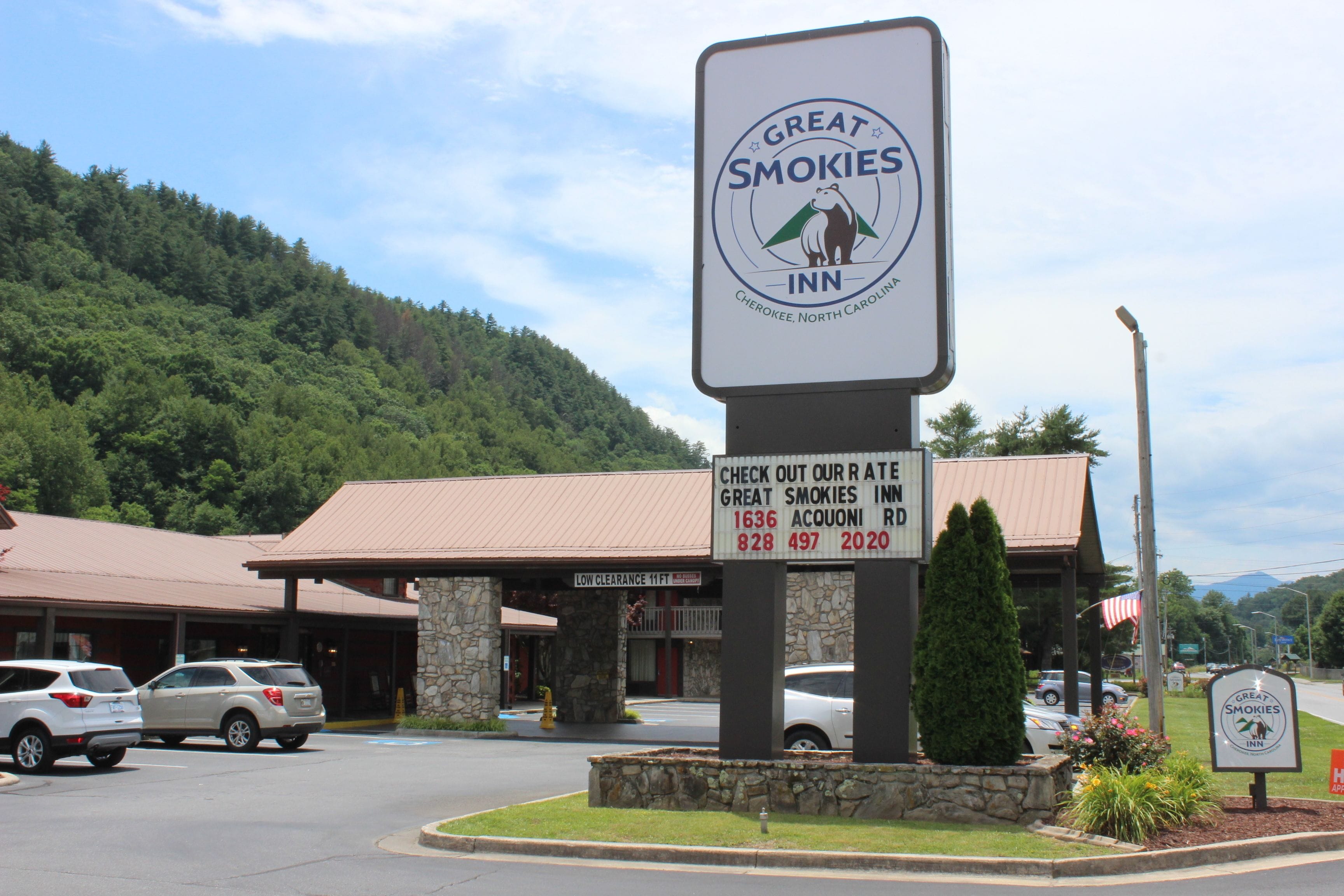 Placa do Great Smokies Inn com paisagem montanhosa ao fundo.