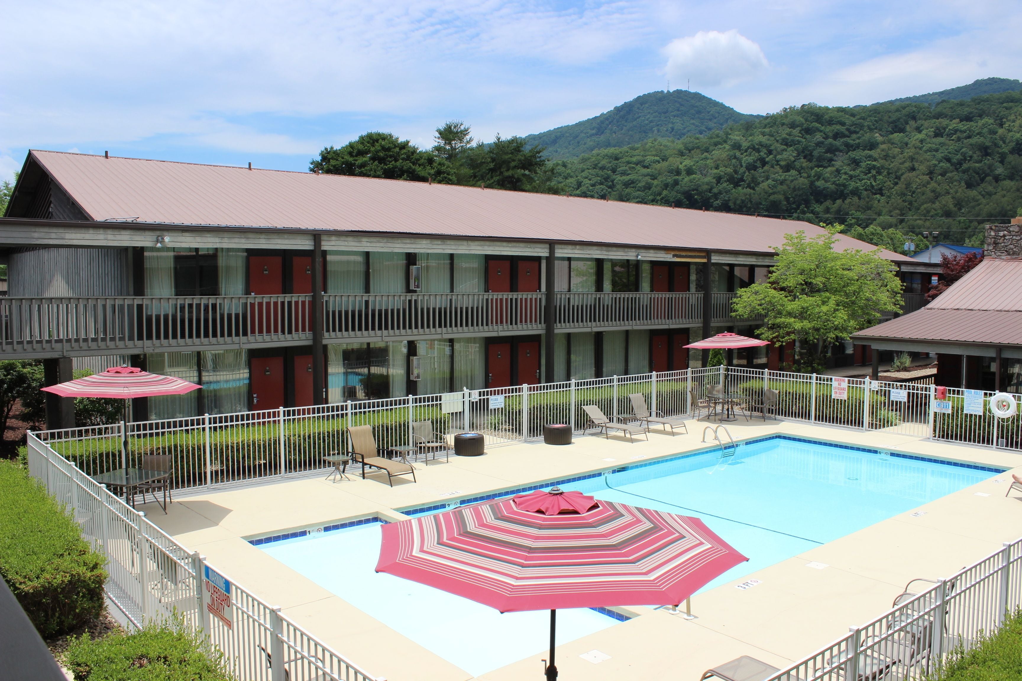 Hotel com piscina, área de estar ao ar livre e vista para uma montanha.