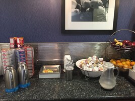 Disposição de buffet de café da manhã com diversas opções de comida e bebidas.