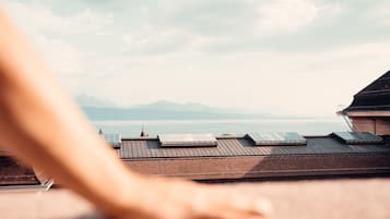Terraço com painéis solares e vista para o mar e montanhas.
