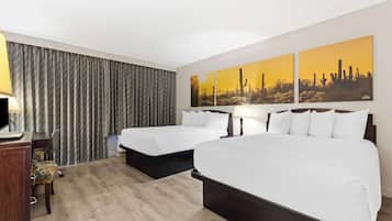 Quarto de hotel com duas camas, uma mesa e uma cadeira.